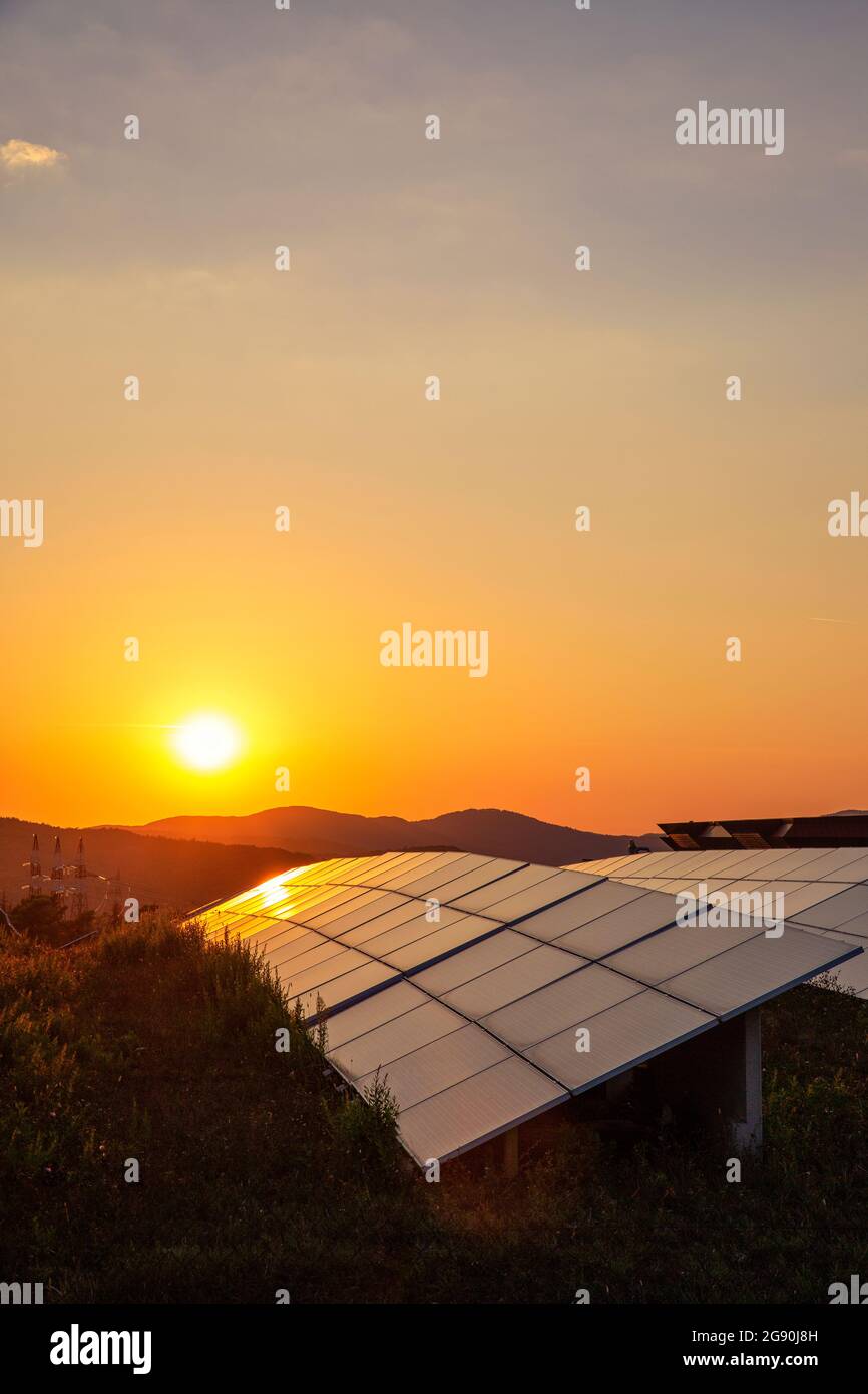 Sun setting over solar farm Stock Photo - Alamy