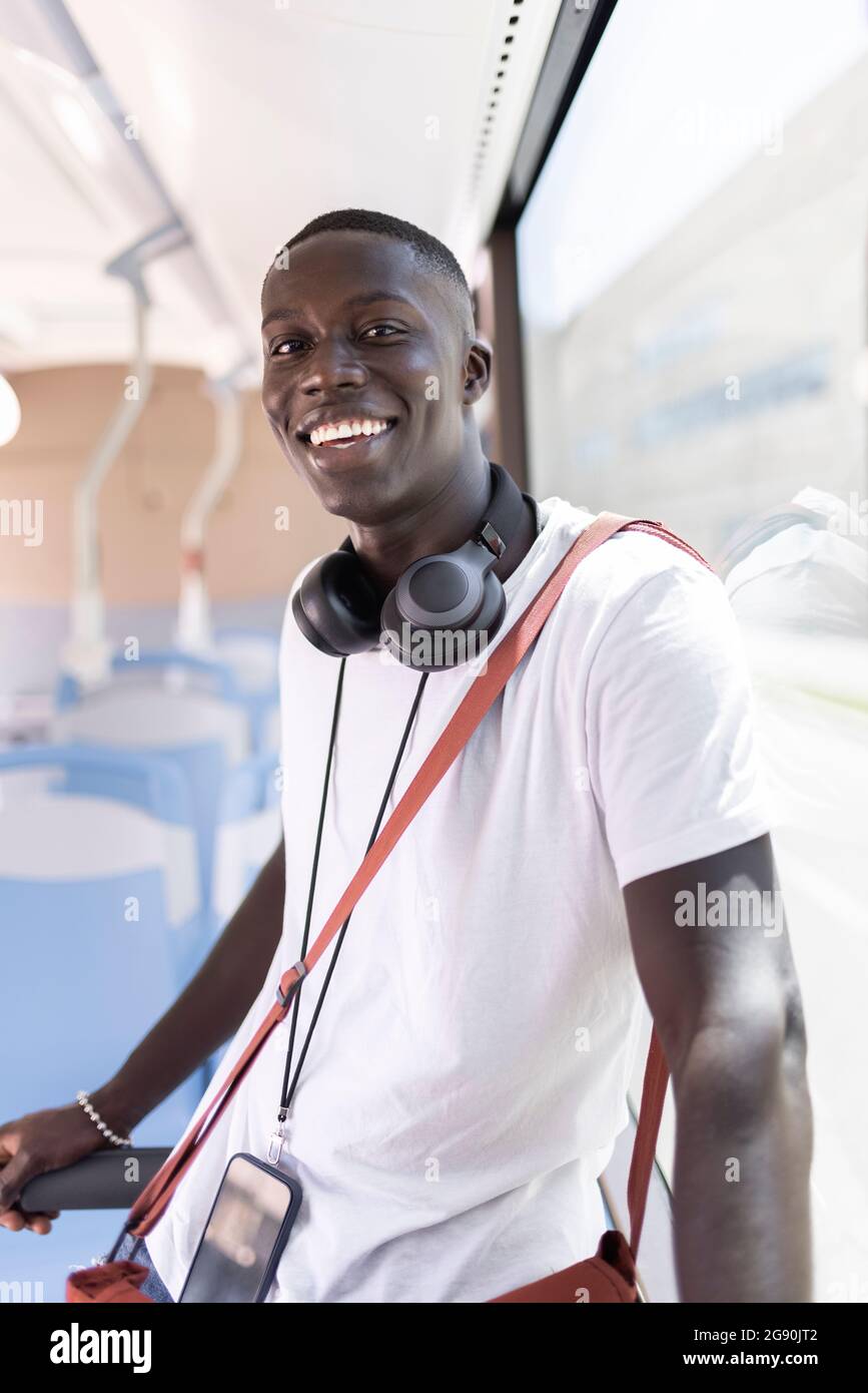 Smiling male professional with shoulder bag and headphones in bus Stock ...