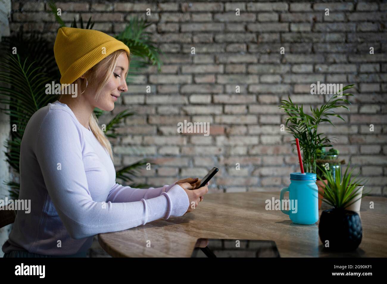 Young woman on table and using phone hi-res stock photography and ...
