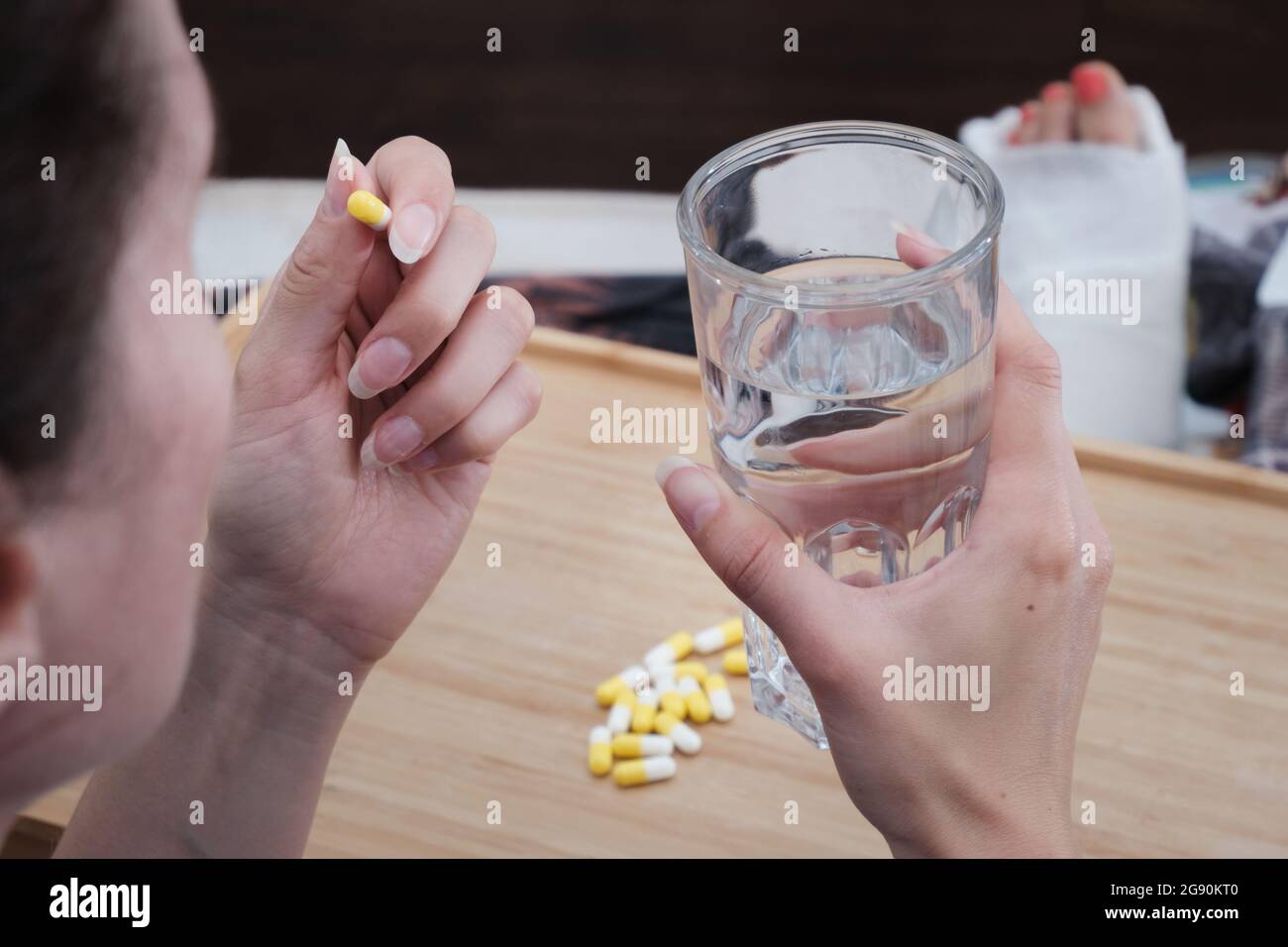 A woman takes a capsule of medicine. Consumption of the drug. Treatment ...
