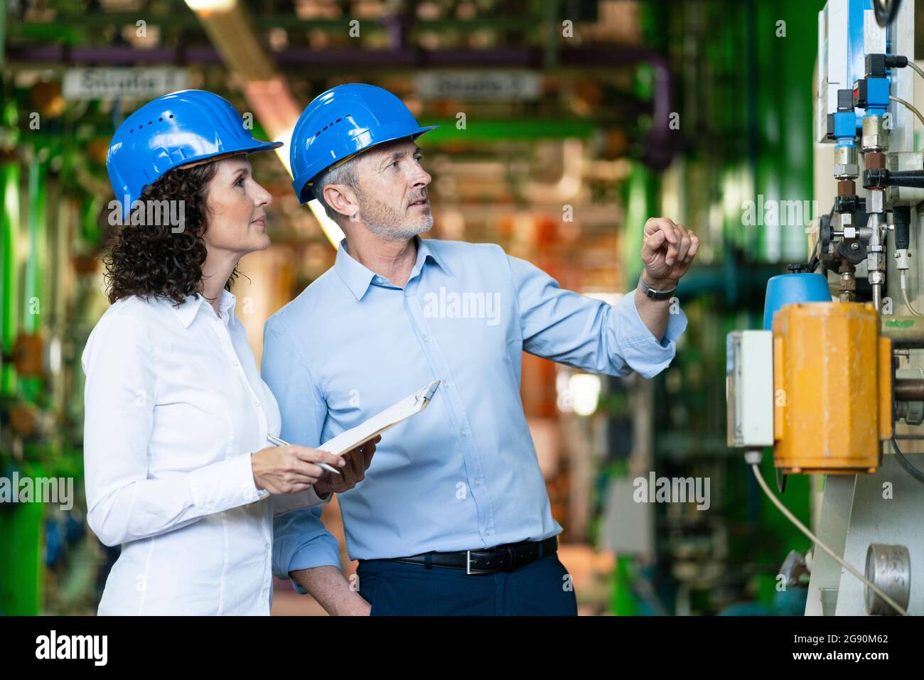 Technician team checking machine while standing at power station Stock ...