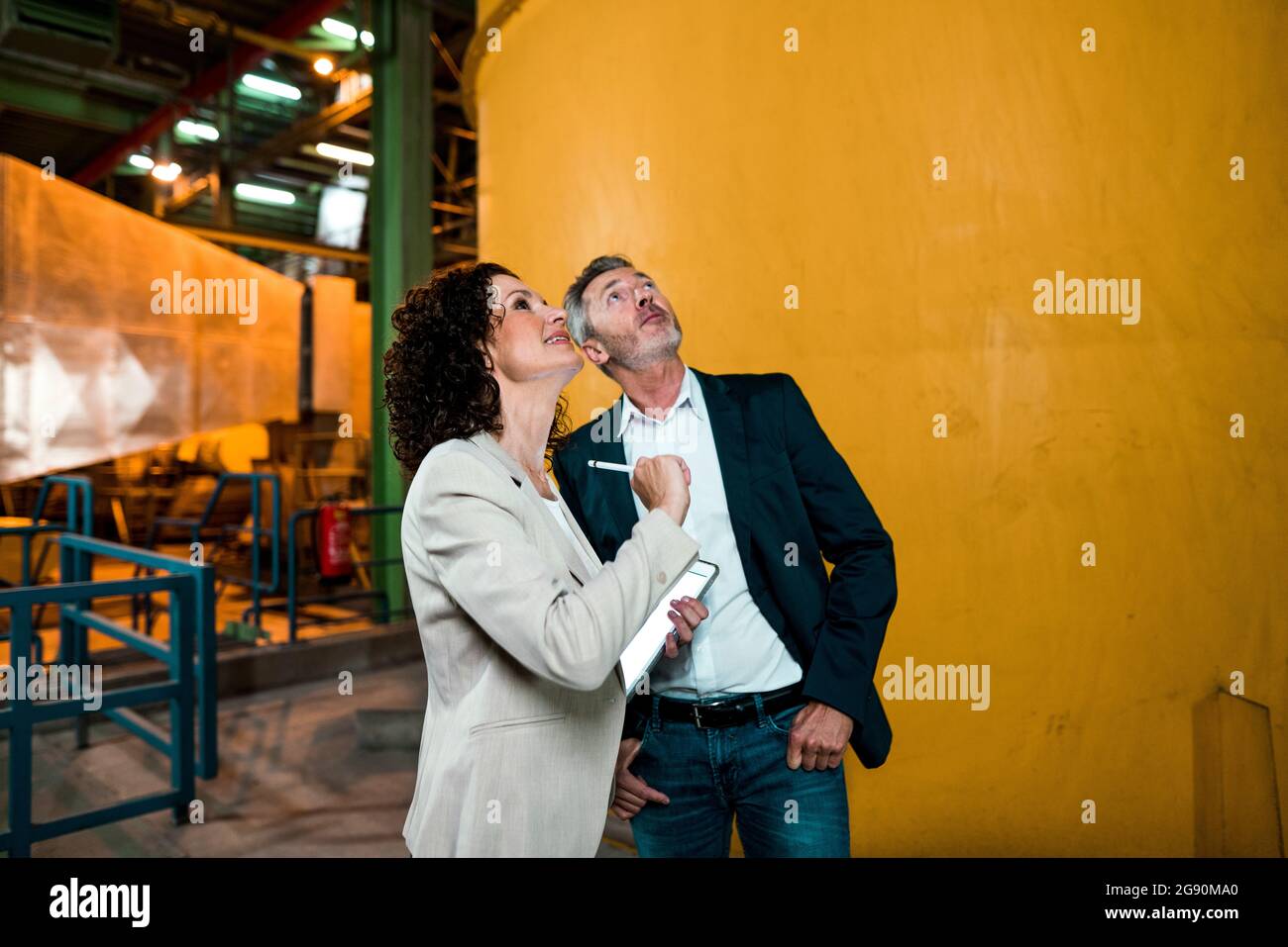 Inspection team with digital tablet looking up in industry Stock Photo ...