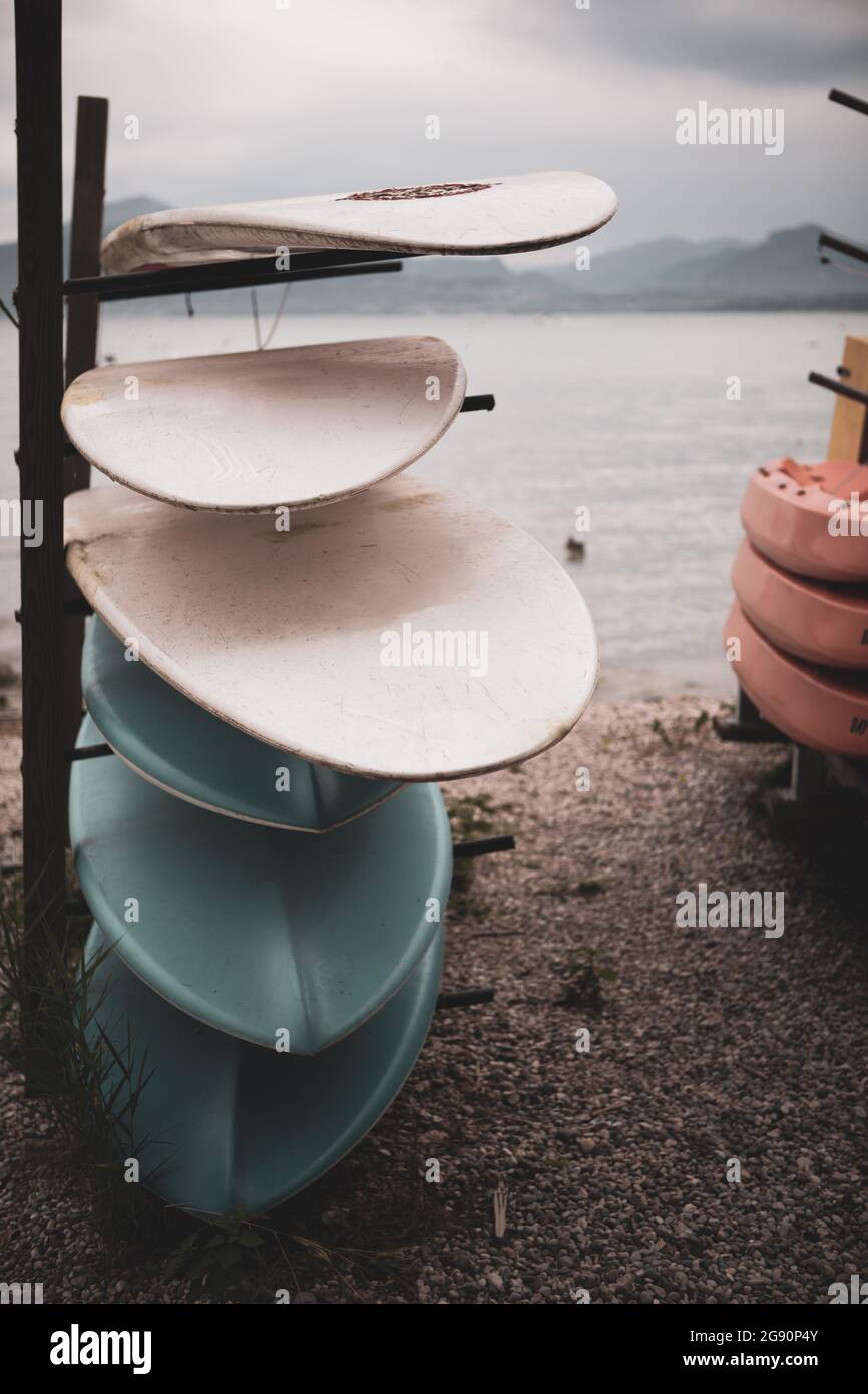 different surfboards are stacked on top of each other on the shore of a ...