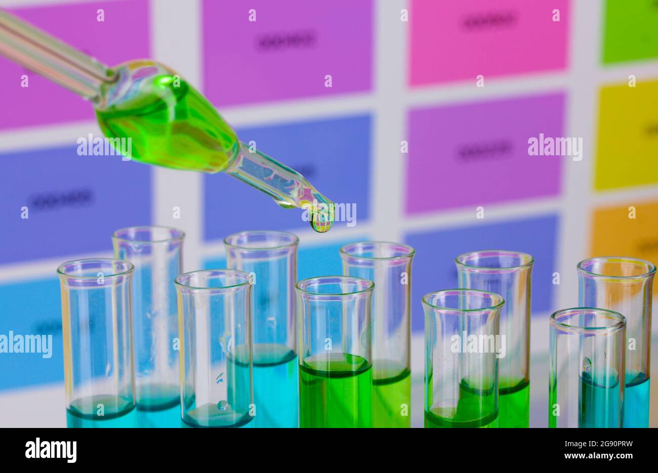 Test-tubes with color liquid and pipette on color samples background ...