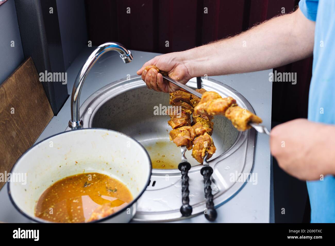 The chef stringing meat on skewers for cooking Stock Photo - Alamy