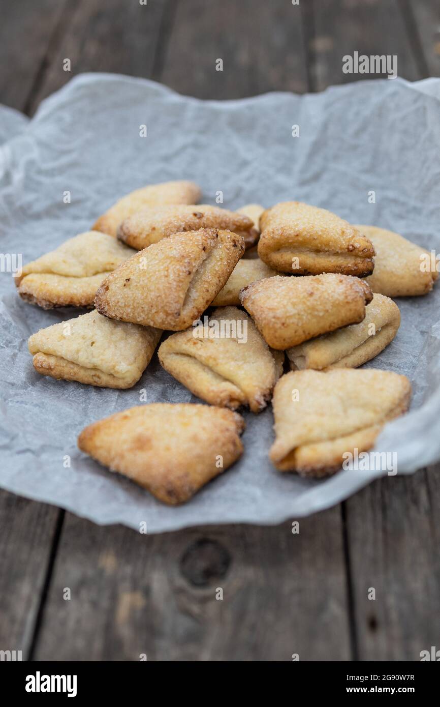 Cottage cheese shortbread triangles on white parchment on an old dark ...