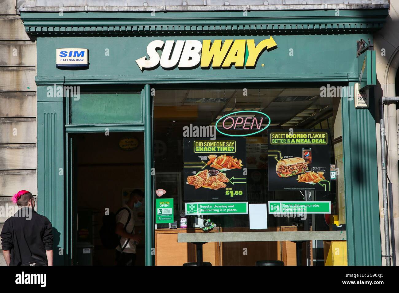 London, UK. 14th July, 2021. A man waits outside a branch of Subway in ...
