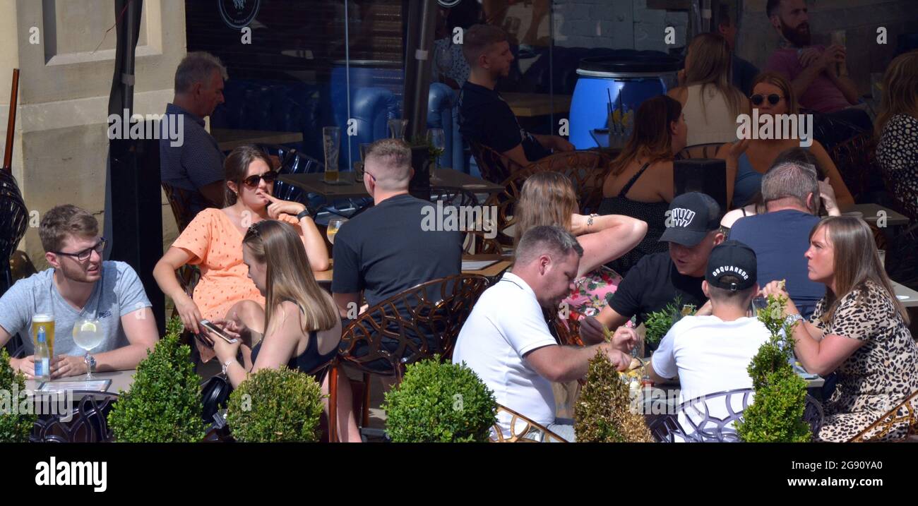 People sit at tables to eat and talk at a restaurant in central ...