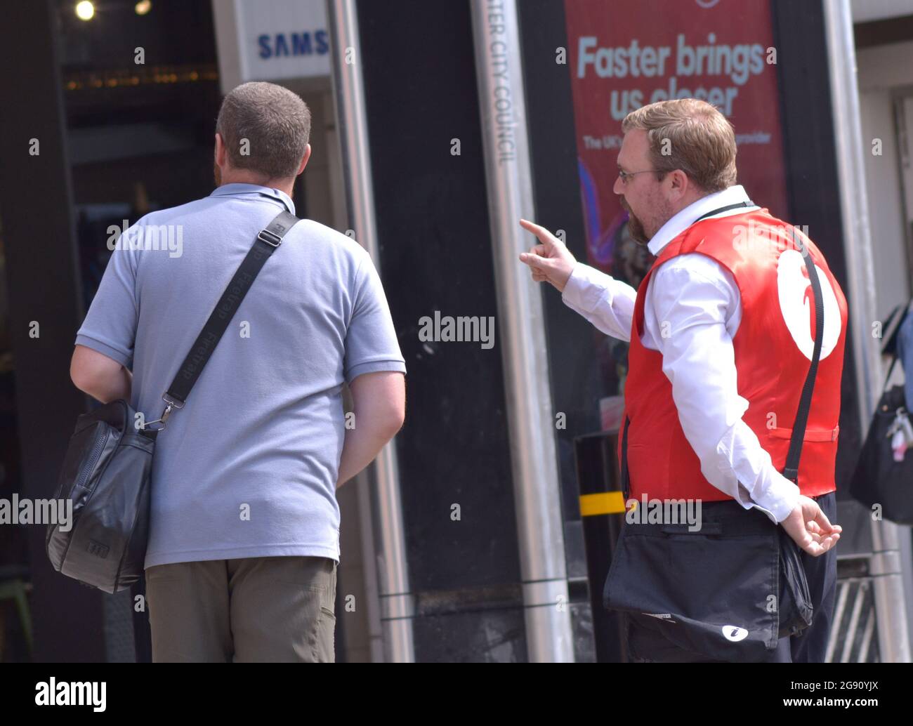 An information worker gives directions to a man in central Manchester ...