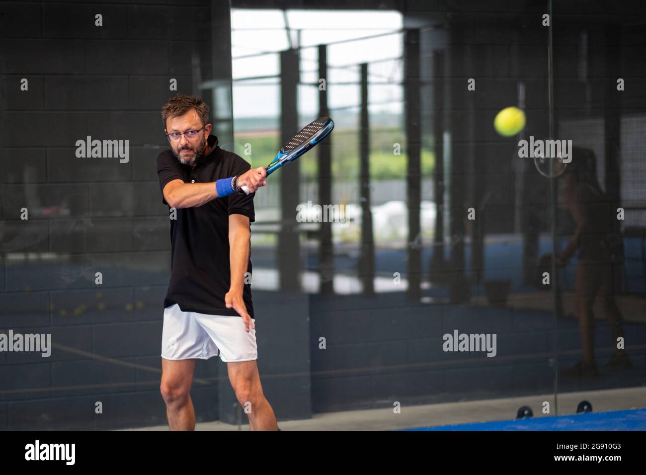 Man playing padel in a blue grass padel court indoor - Young sporty boy ...
