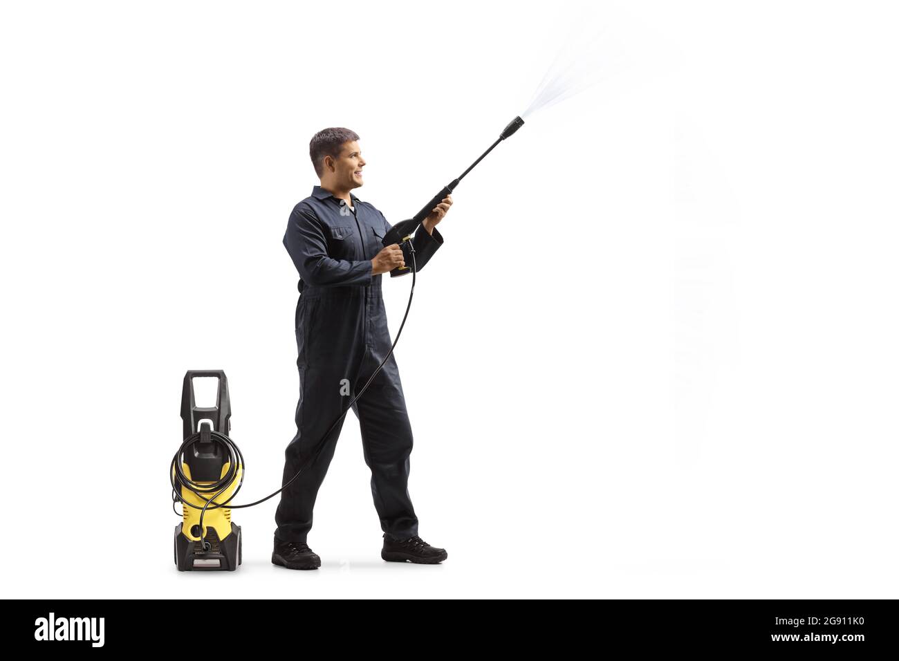 Full length shot of a male worker in a uniform spraying with a pressure ...