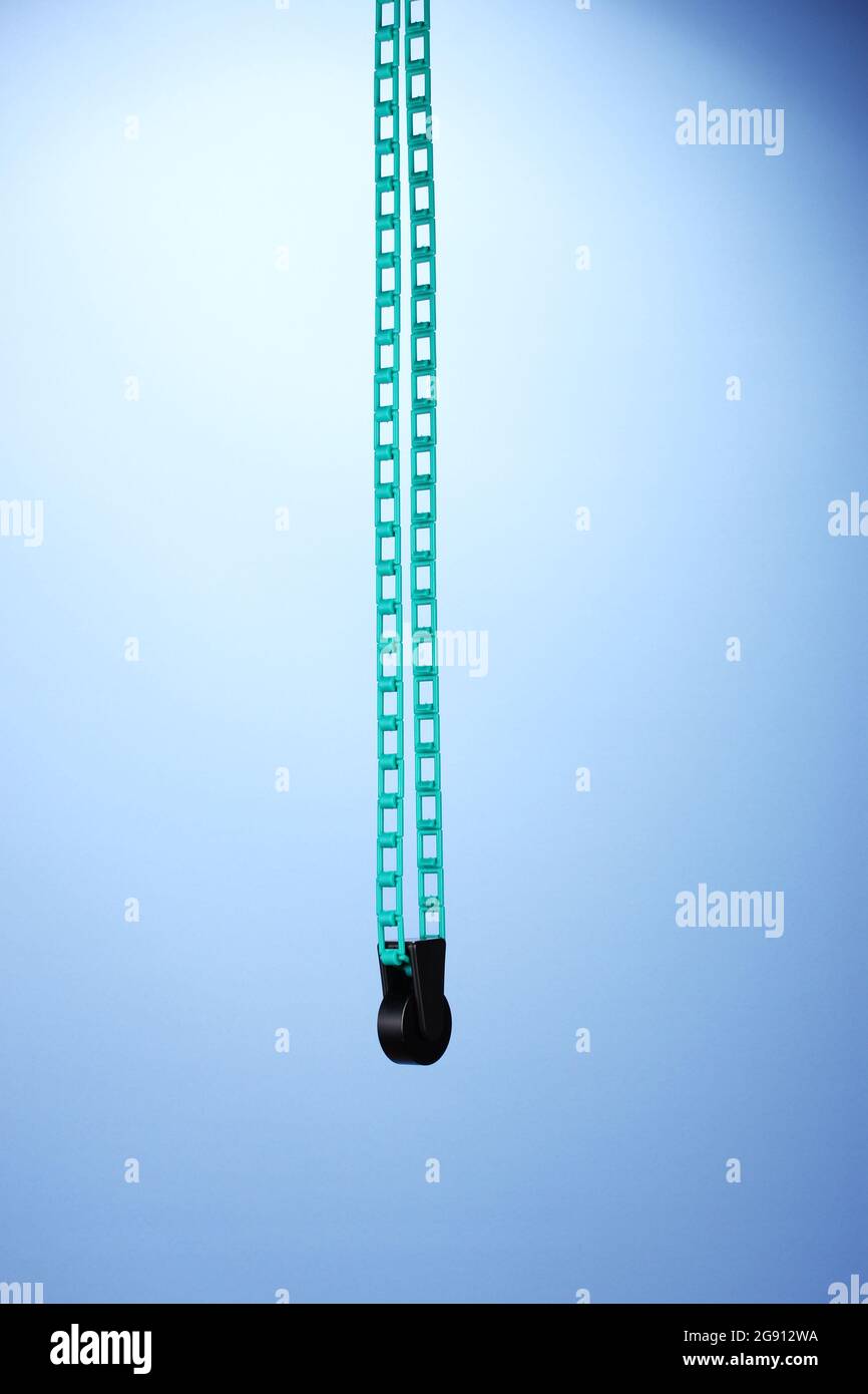 Lifting chain for studio background on blue background Stock Photo - Alamy