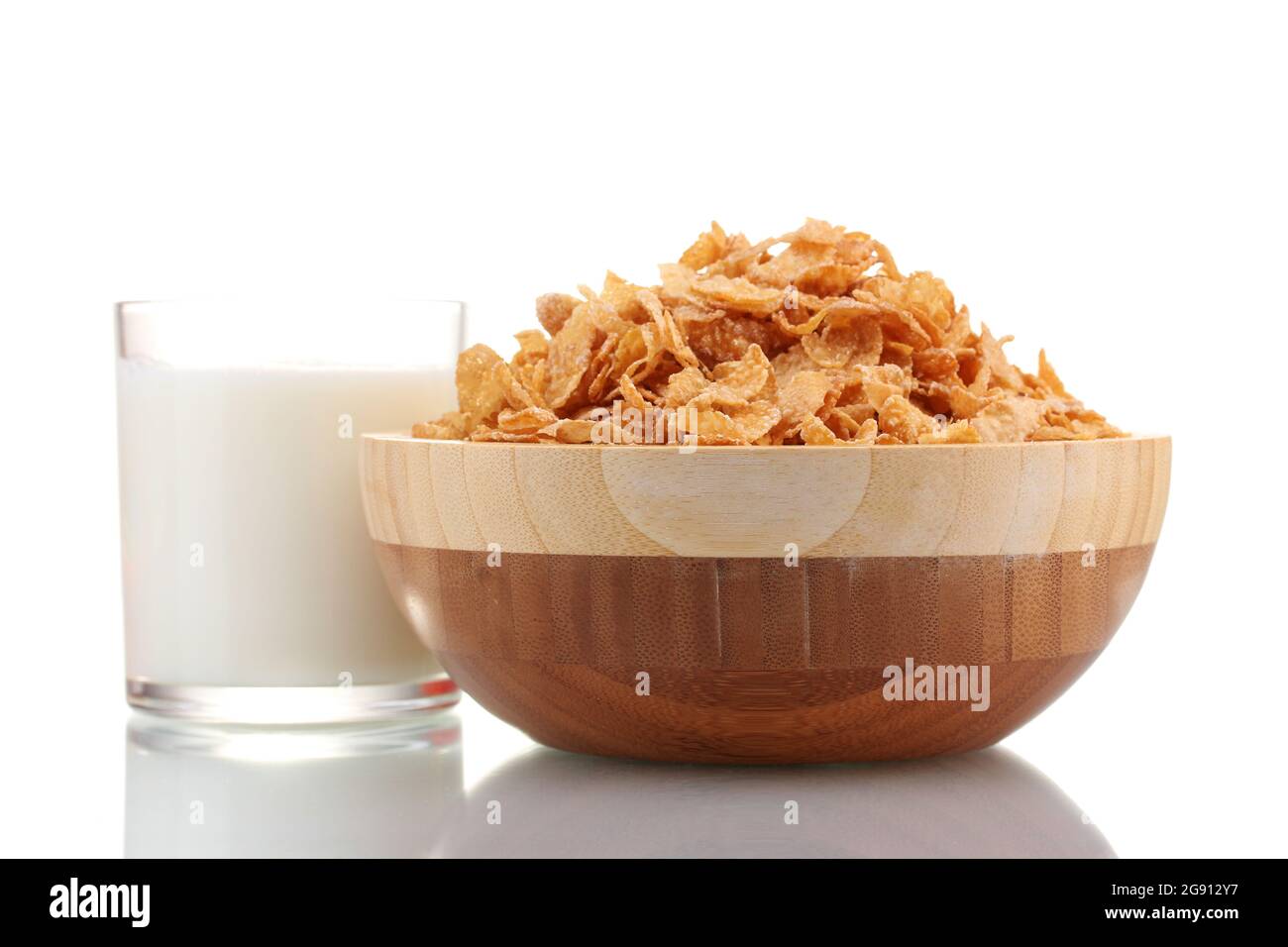 tasty cornflakes in wooden bowl and glass of milk isolated on white ...