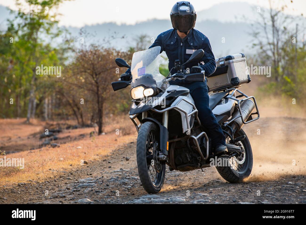 Man riding his adventure motorbike on dirt road in Cambodia Stock Photo ...