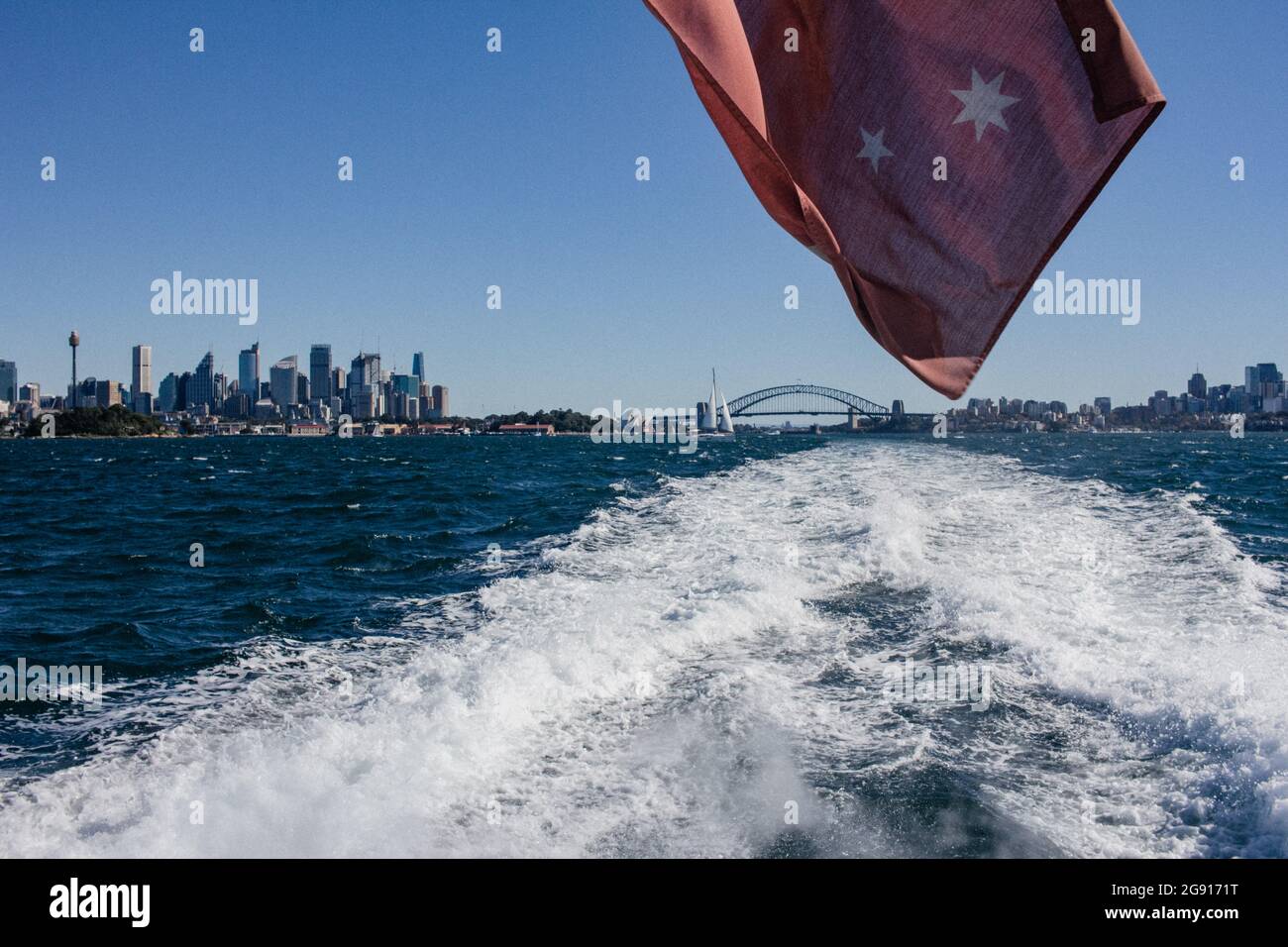 Sydney landscape from a boat, red australian flog Stock Photo - Alamy