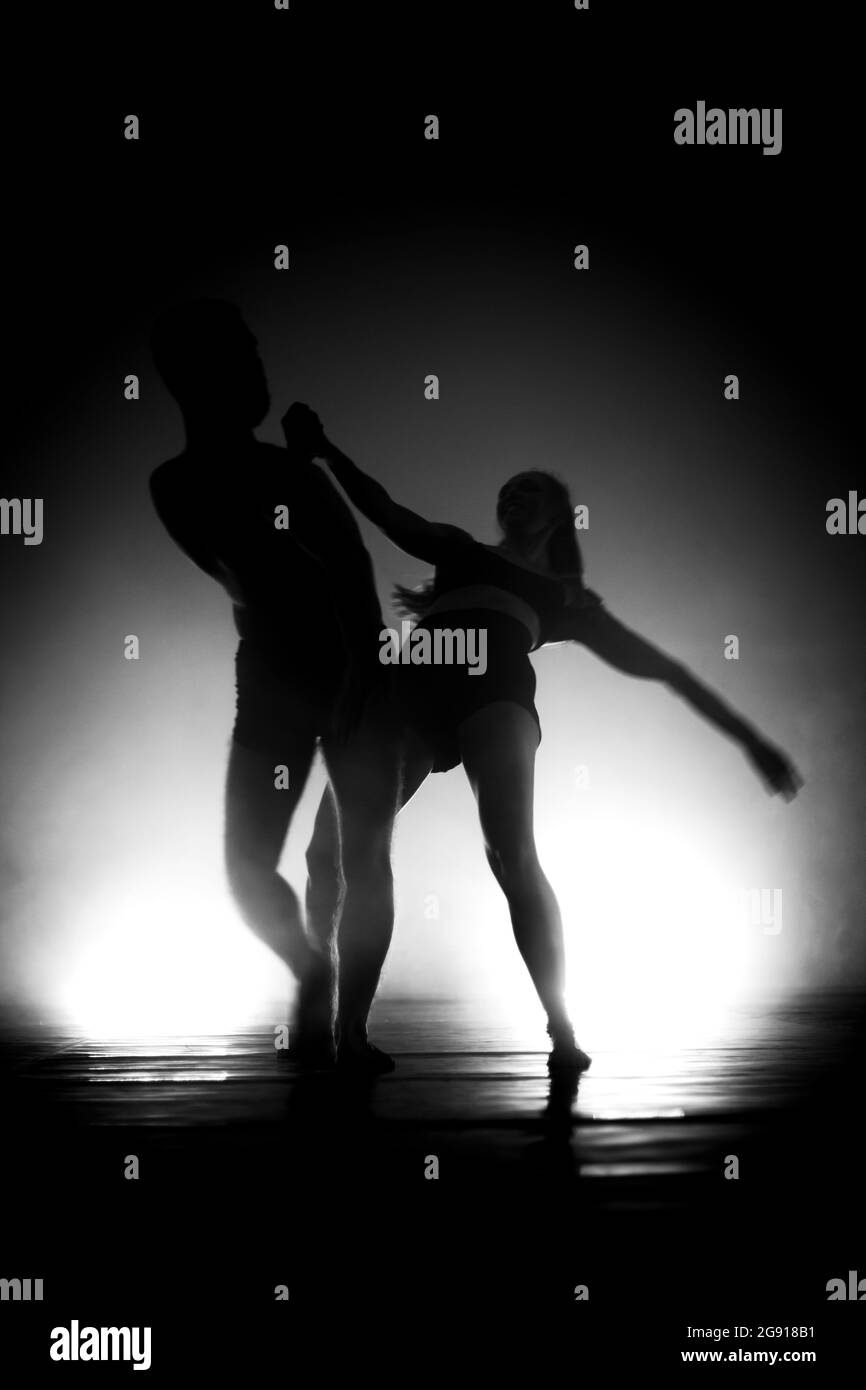 modern ballet dancers performing. motion blur and smoke in the air ...