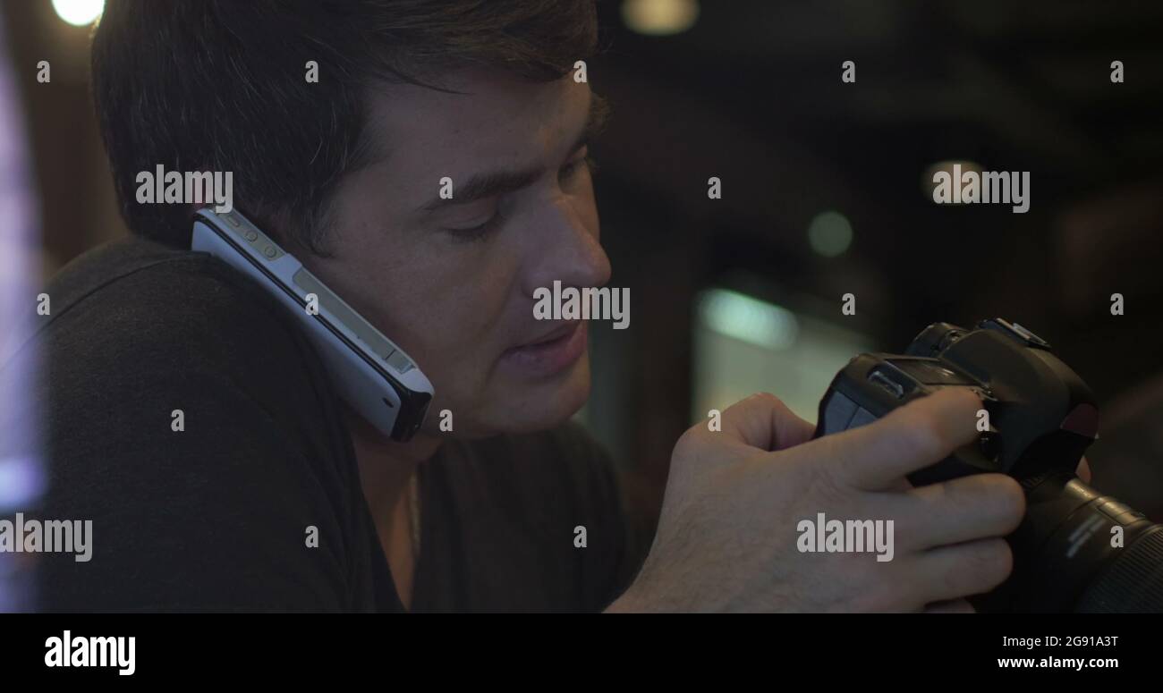Man talking on phone and using camera Stock Photo - Alamy