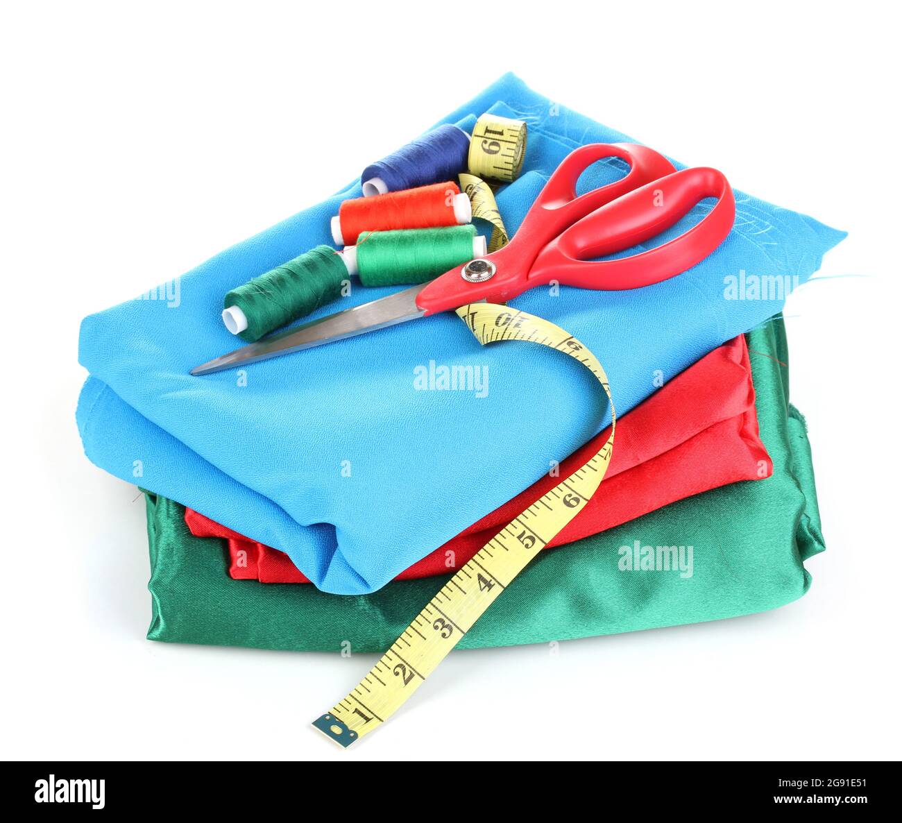 Scissors, bright thread and measuring tape on fabric isolated on white ...