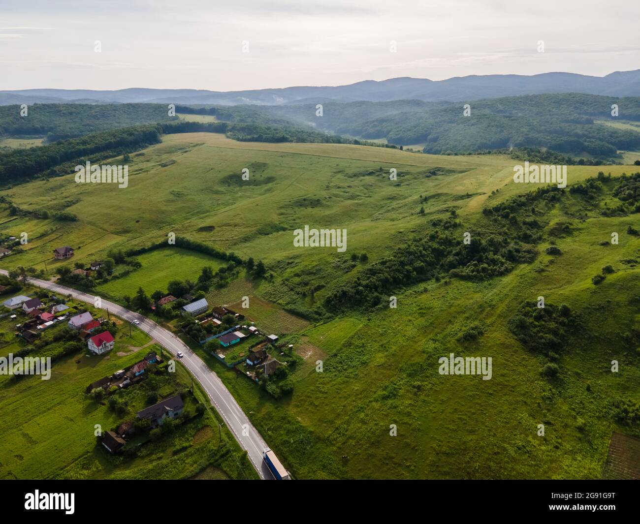 Aerial view of rural Romania, with houses, green forests and fields ...