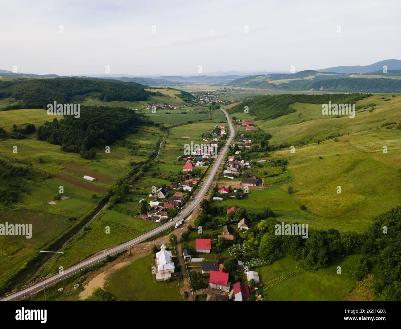 Aerial view of rural Romania, with houses, green forests and fields ...