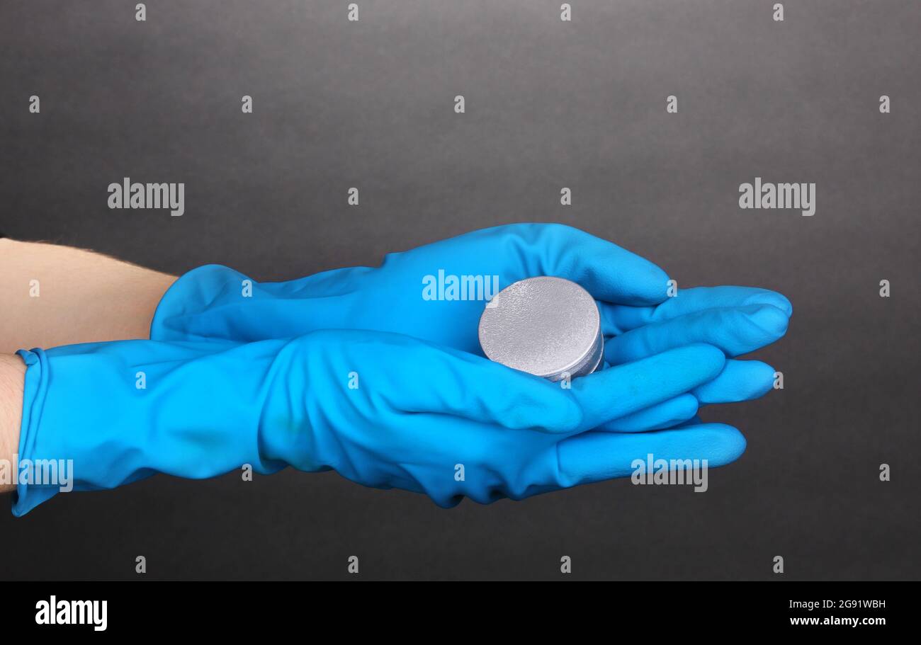 Uranium in hands on grey background Stock Photo - Alamy