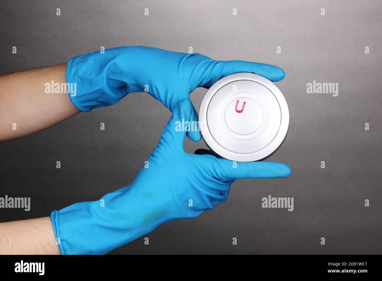 Uranium in hands on grey background Stock Photo - Alamy