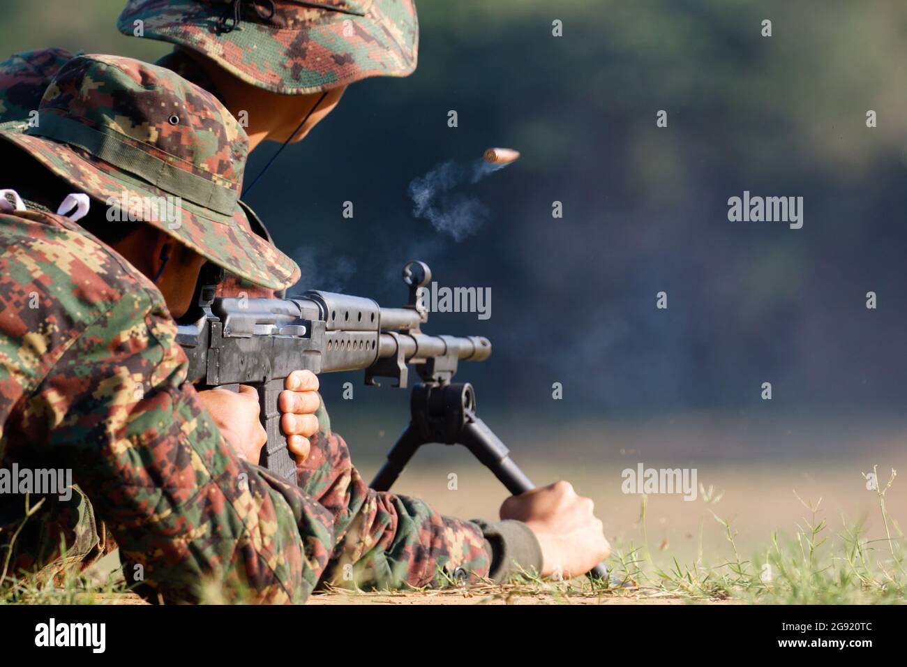Soldier firing rifle gun to target with bullet cartridge in the air ...