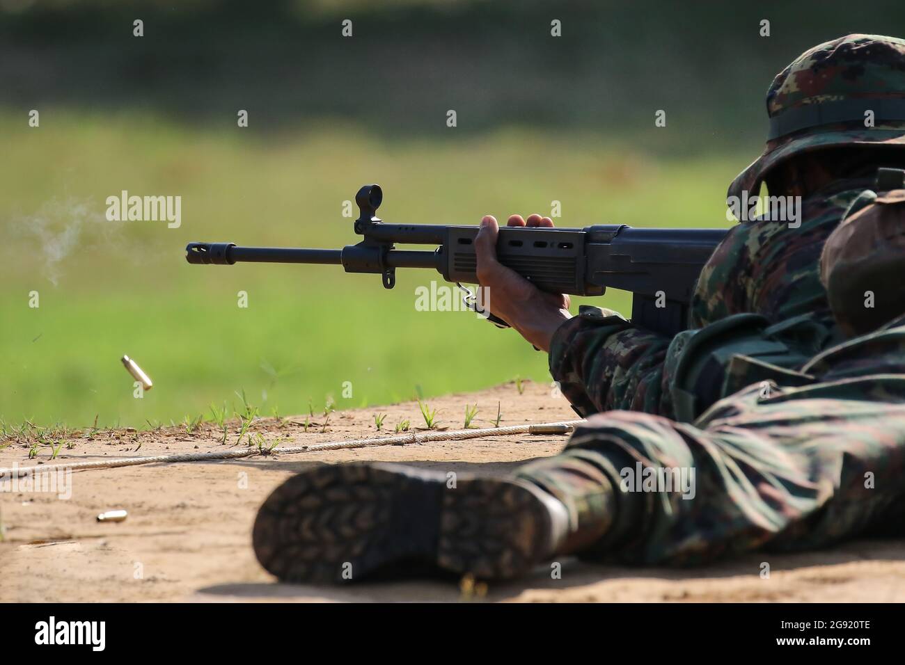 Soldier firing rifle gun to target with bullet cartridge in the air ...