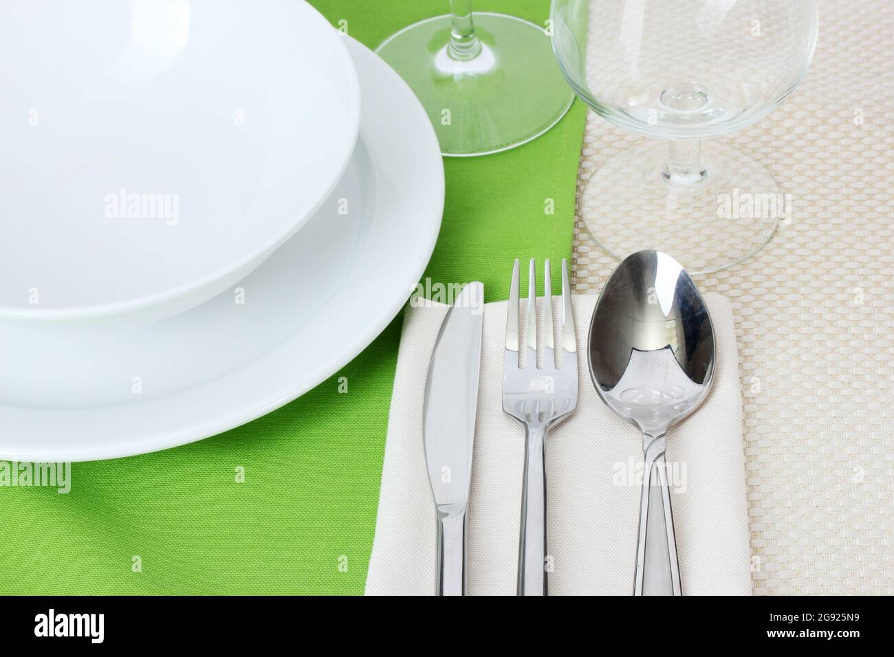 Table setting with fork, knife, spoon, plates, and napkin Stock Photo ...