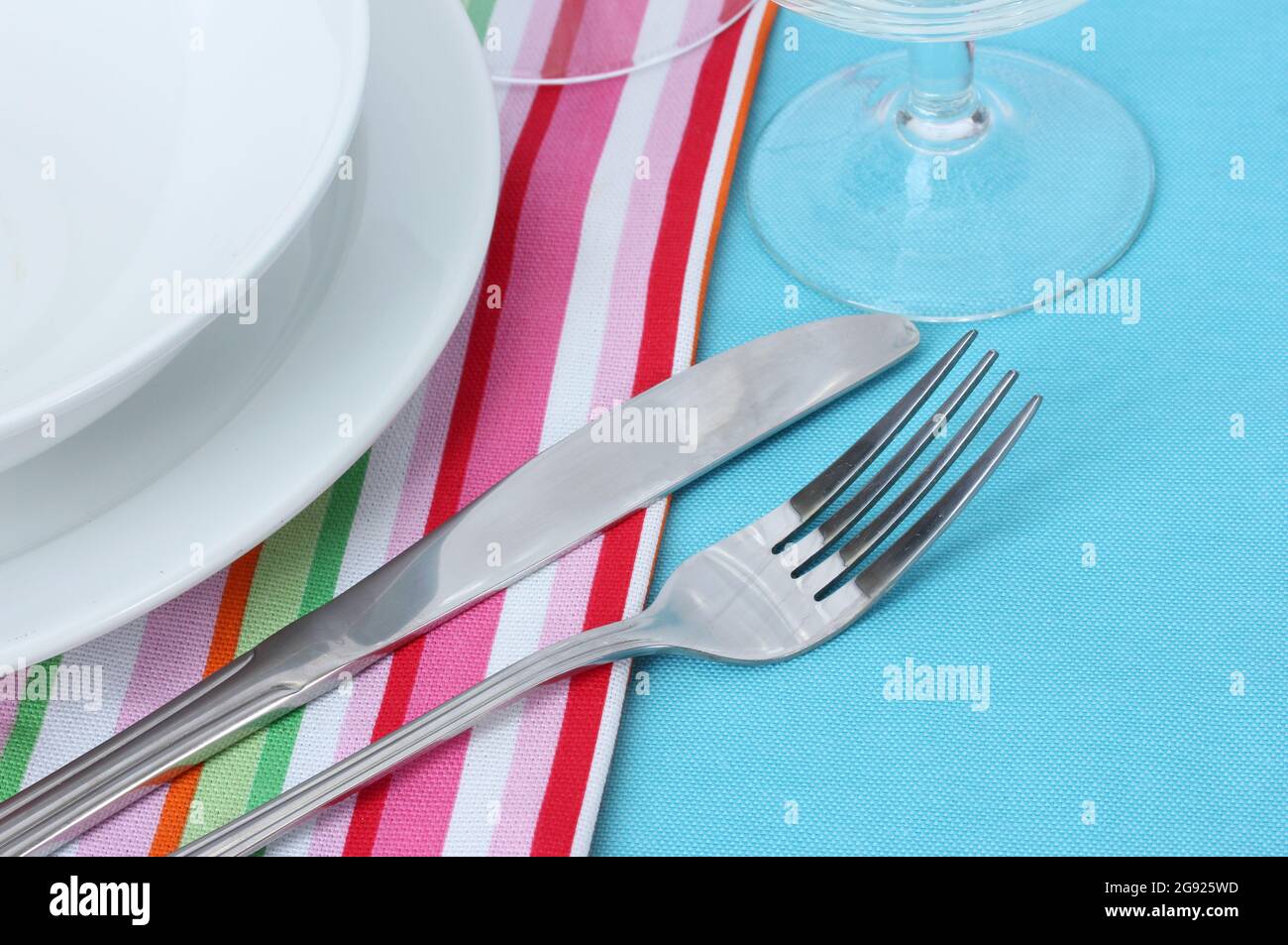 Table setting with fork, knife, plates, and napkin Stock Photo - Alamy