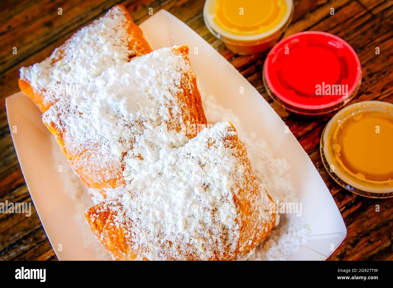 Beignets are served with buttercream, raspberry, and cinnamon dipping ...
