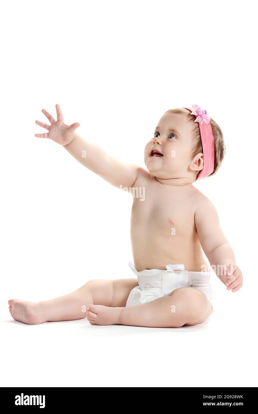 Cute baby girl sitting and pulling hand isolated on white Stock Photo ...