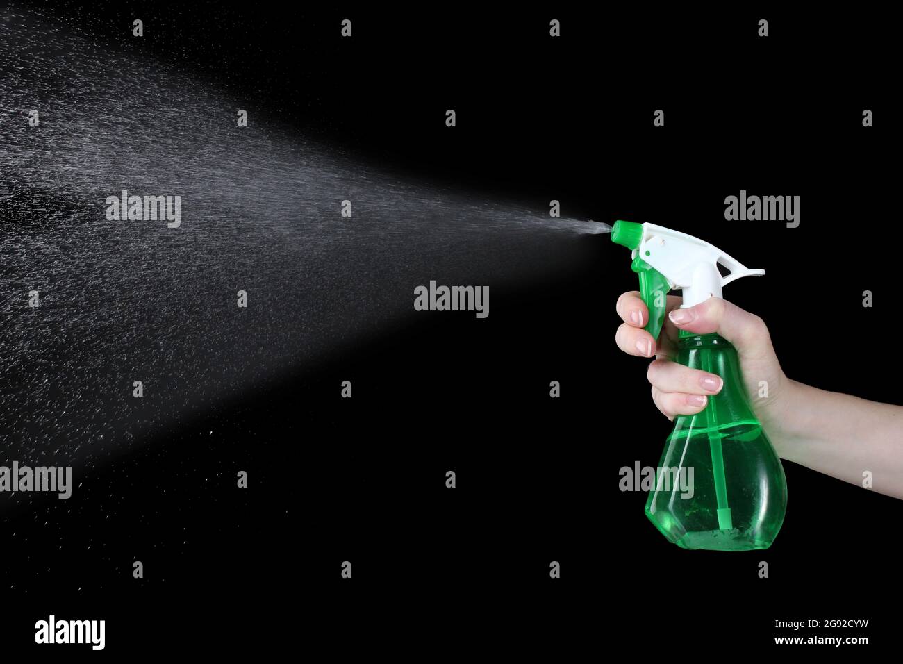 hand holding spray bottle and spraying on black background Stock Photo ...