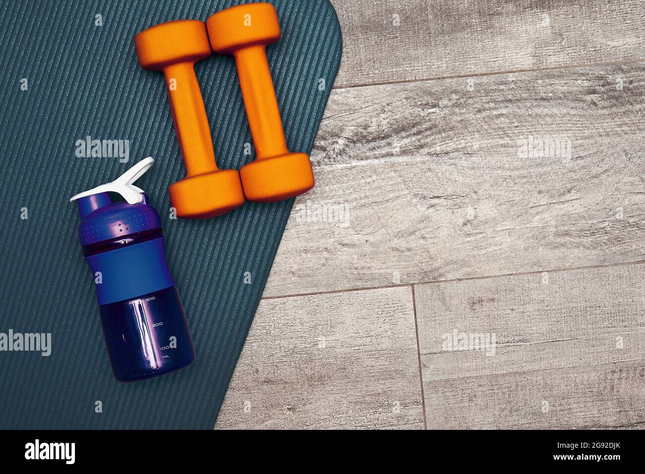 Colorful bright fitness stuff is scattered on the gym floor. Dumbbell ...