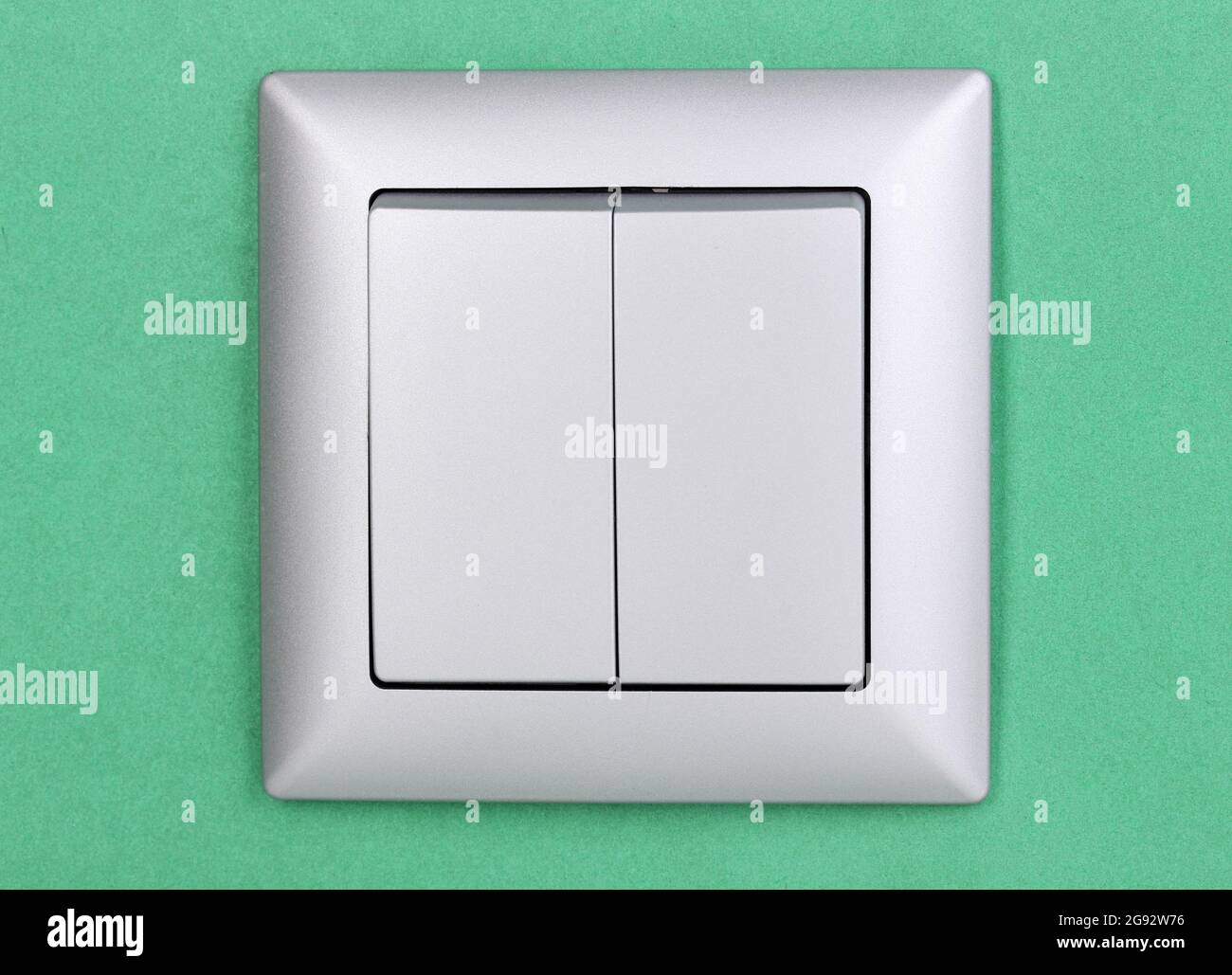 Modern light switch on green background Stock Photo - Alamy