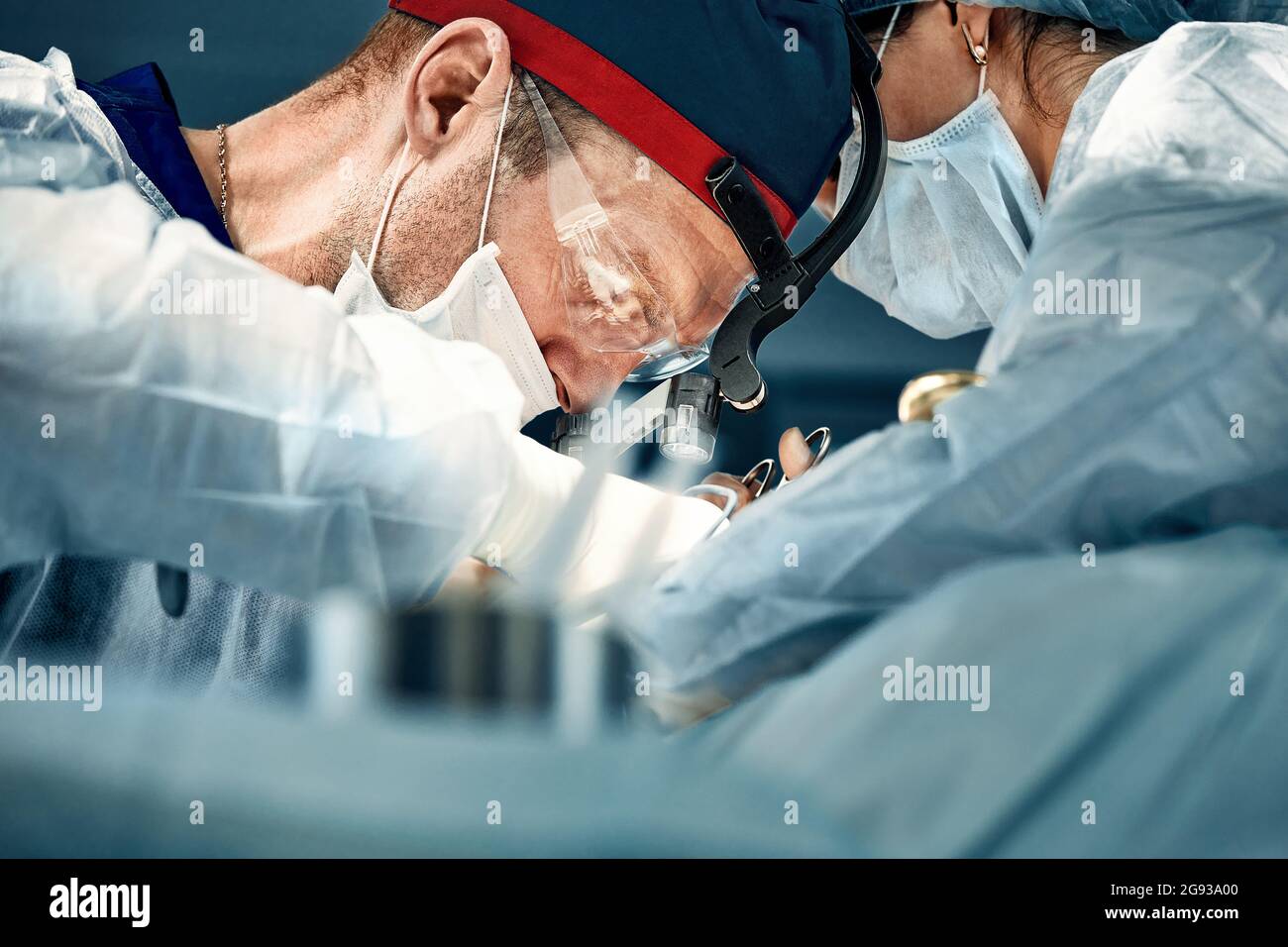 Surgeons are operating, a team of male and female doctors during the ...