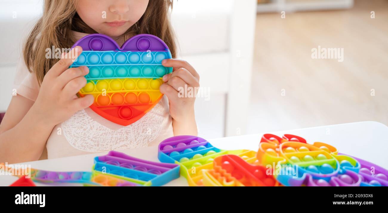 Little girl,kid,child plays with colorful pop it children's room ...