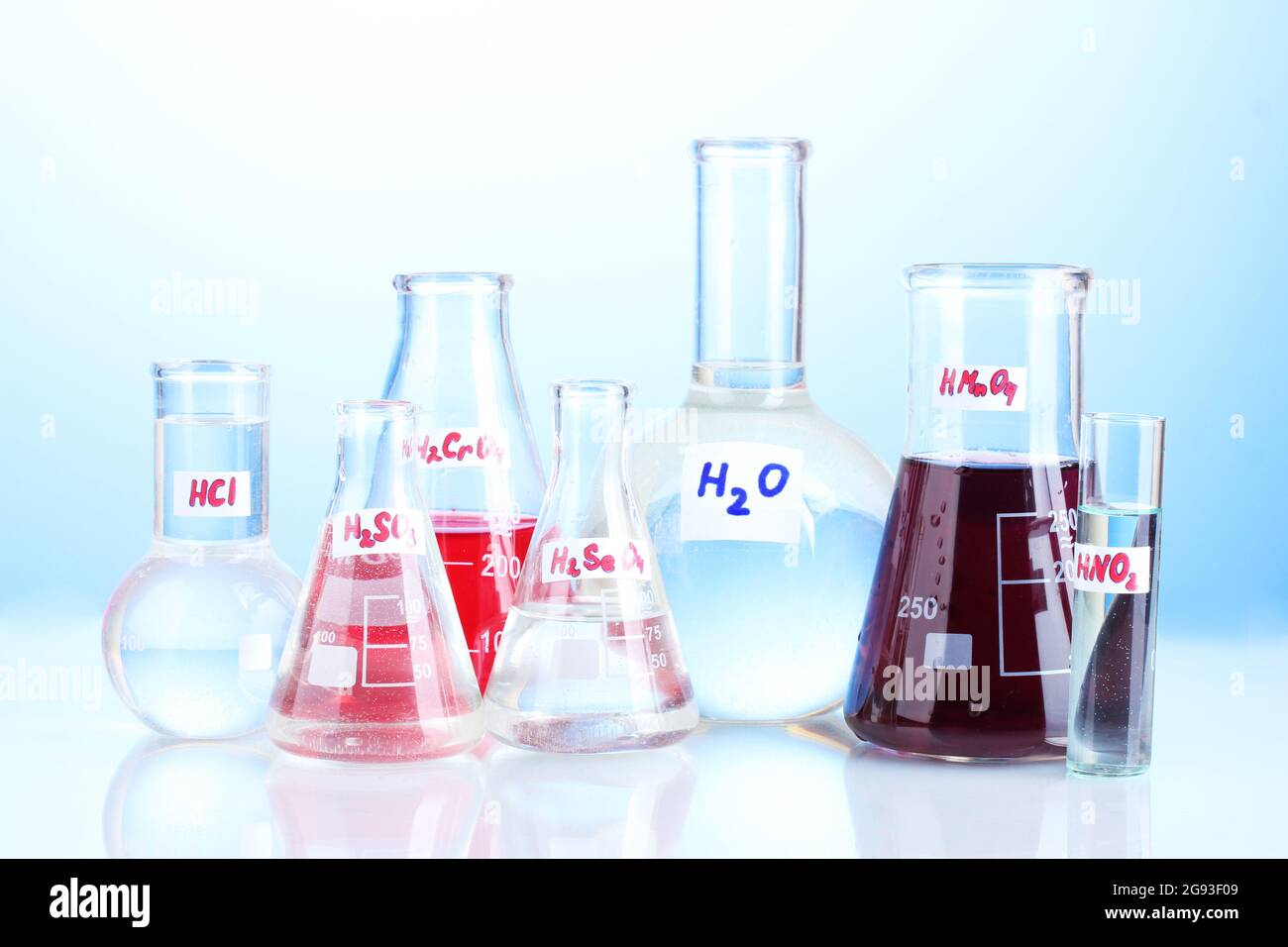 Test-tubes with various acids on blue background Stock Photo - Alamy