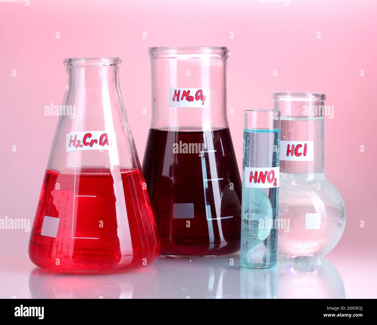 Test-tubes with various acids and chemicals on pink background Stock ...