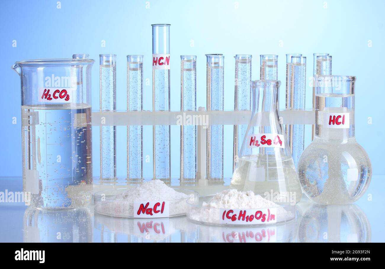 Test-tubes with various acids and chemicals on blue background Stock ...