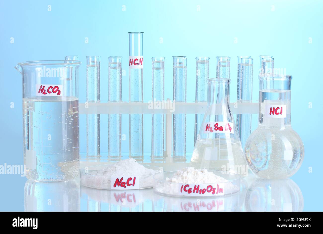 Test-tubes with various acids and chemicals on blue background Stock ...
