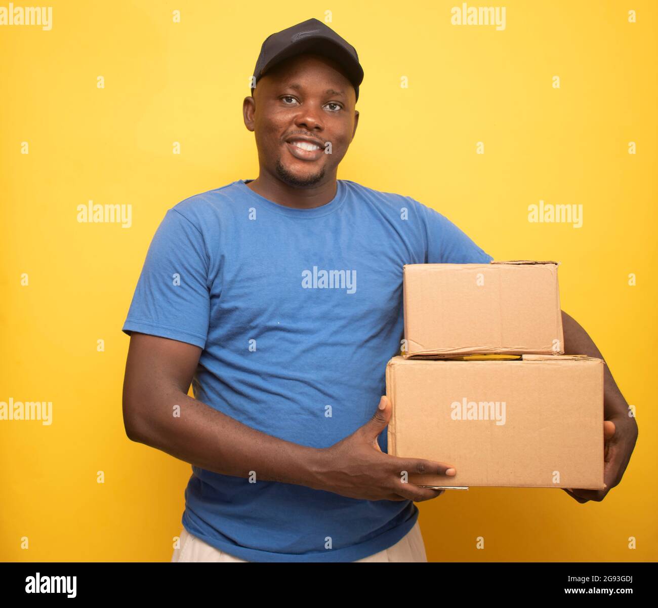 Happy african delivery man with box Stock Photo - Alamy