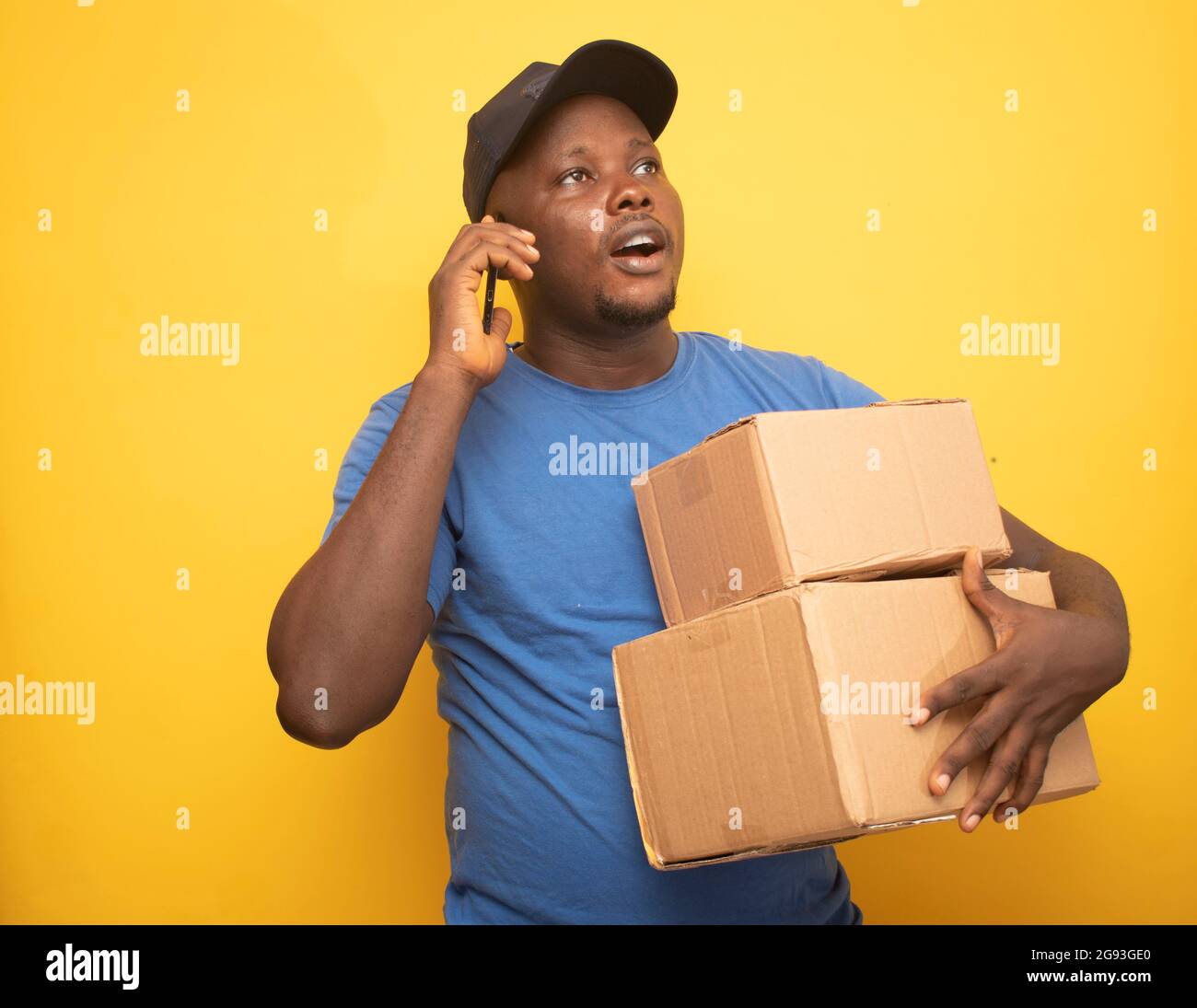 Happy african delivery man with box Stock Photo - Alamy