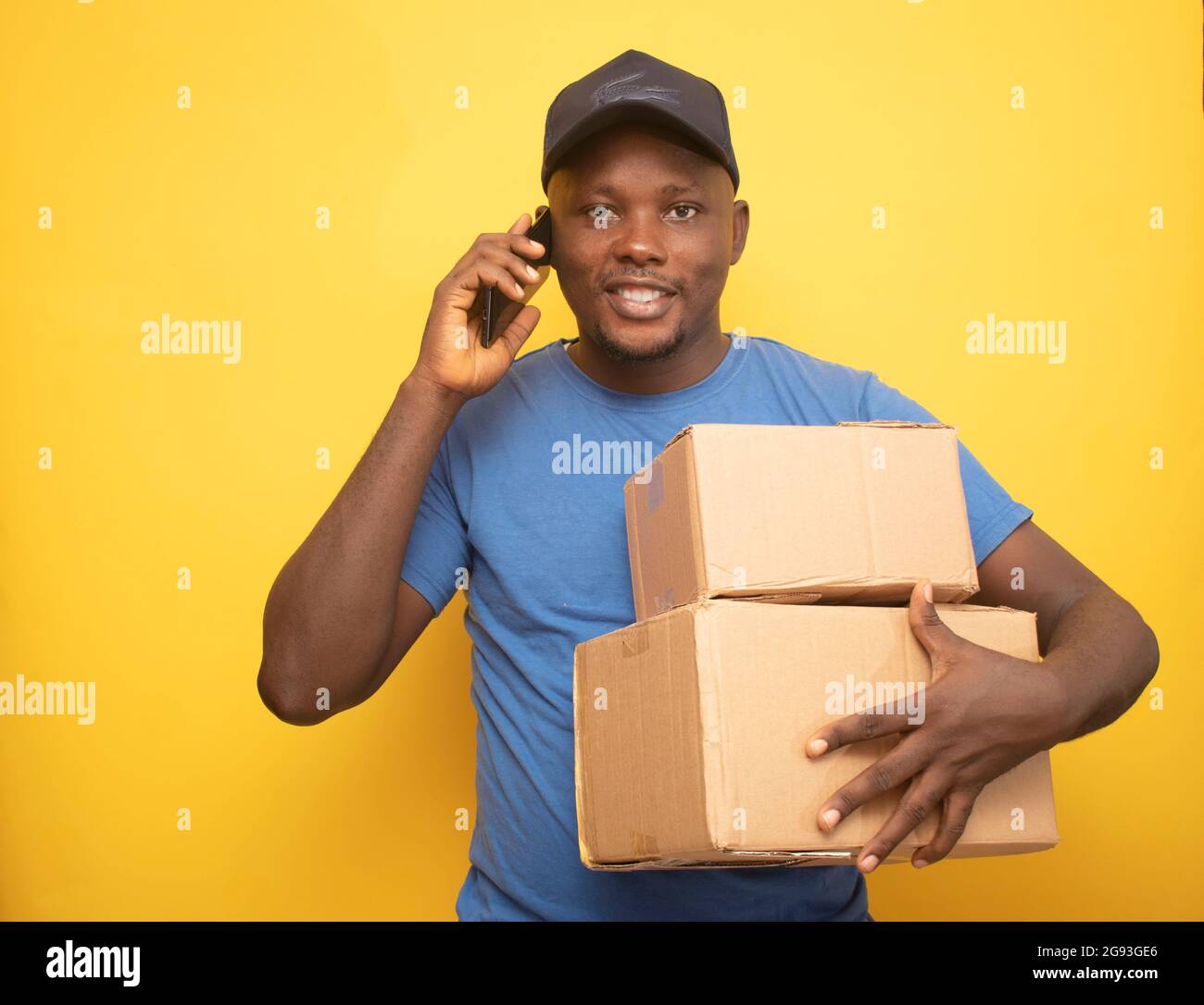 Happy african delivery man with box Stock Photo - Alamy