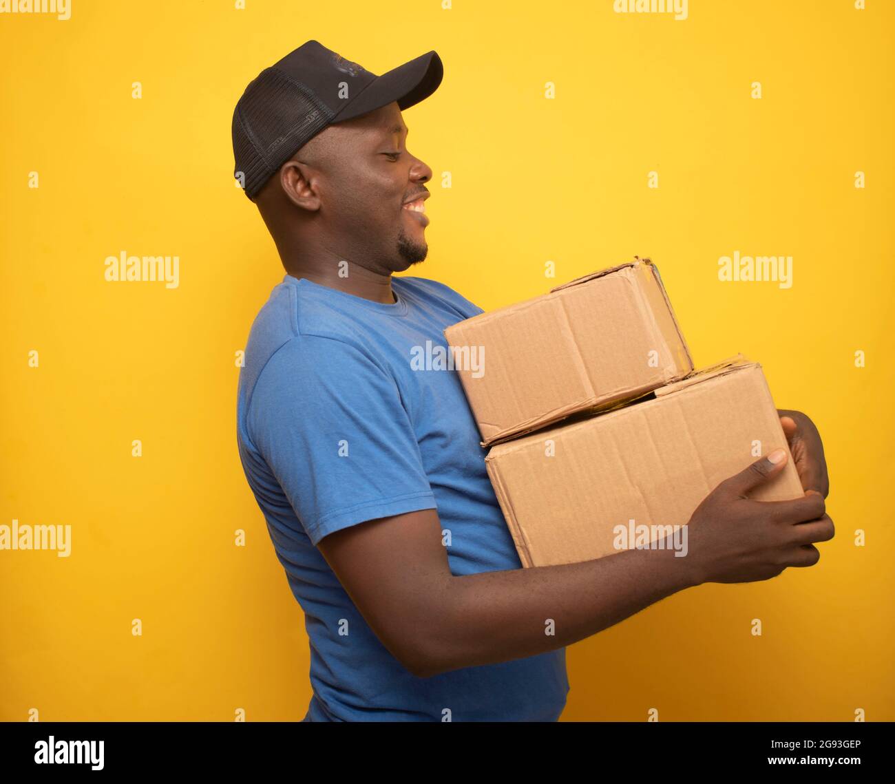 Happy african delivery man with box Stock Photo - Alamy