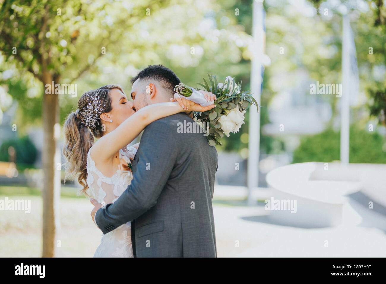Hugging wedding couple is posing in the open air and kissing Stock ...
