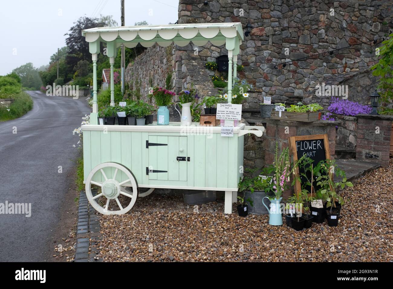 June 2021 - Pastel green painted flower barrow in the road side in ...