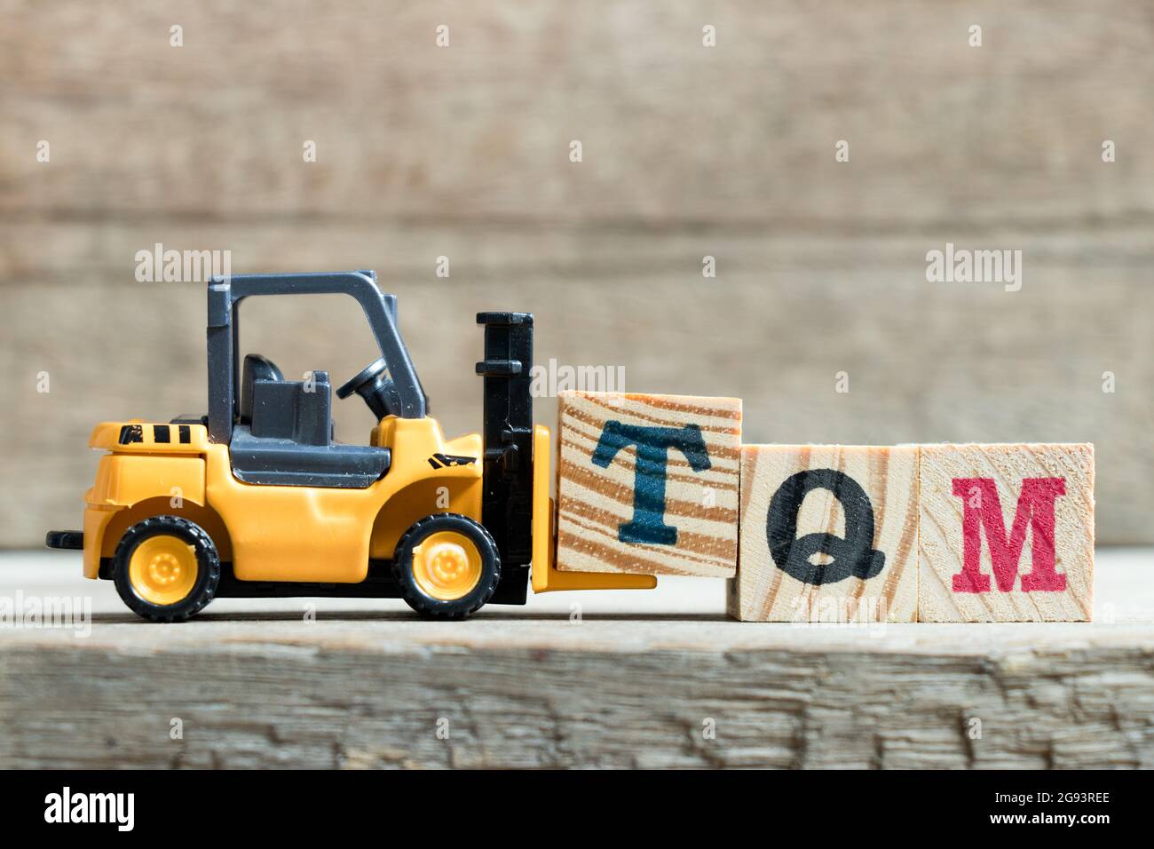 Toy yellow forklift hold letter block T to complete word T ...