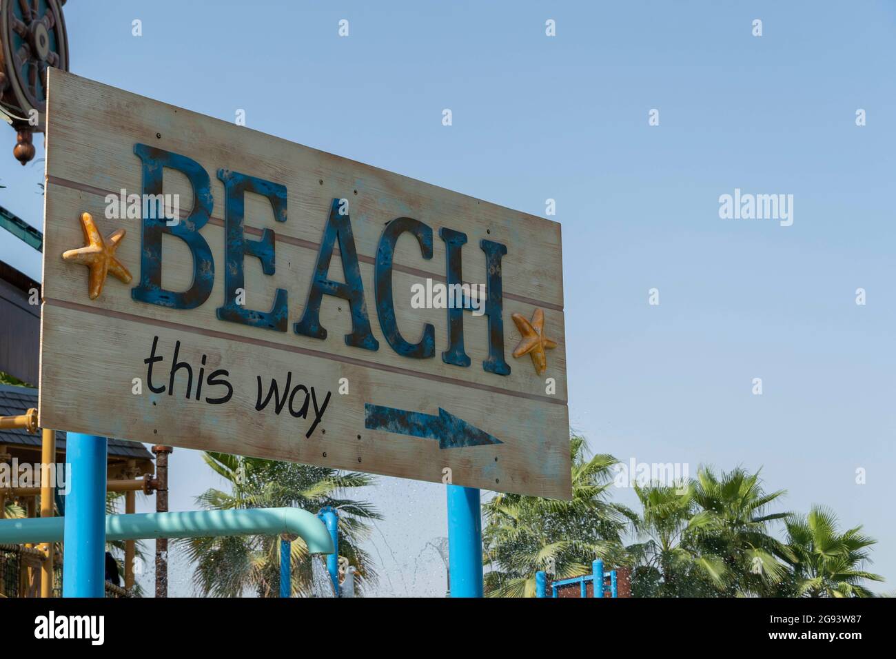 Tropical Beach this way directional sign with copy space on blue sky ...