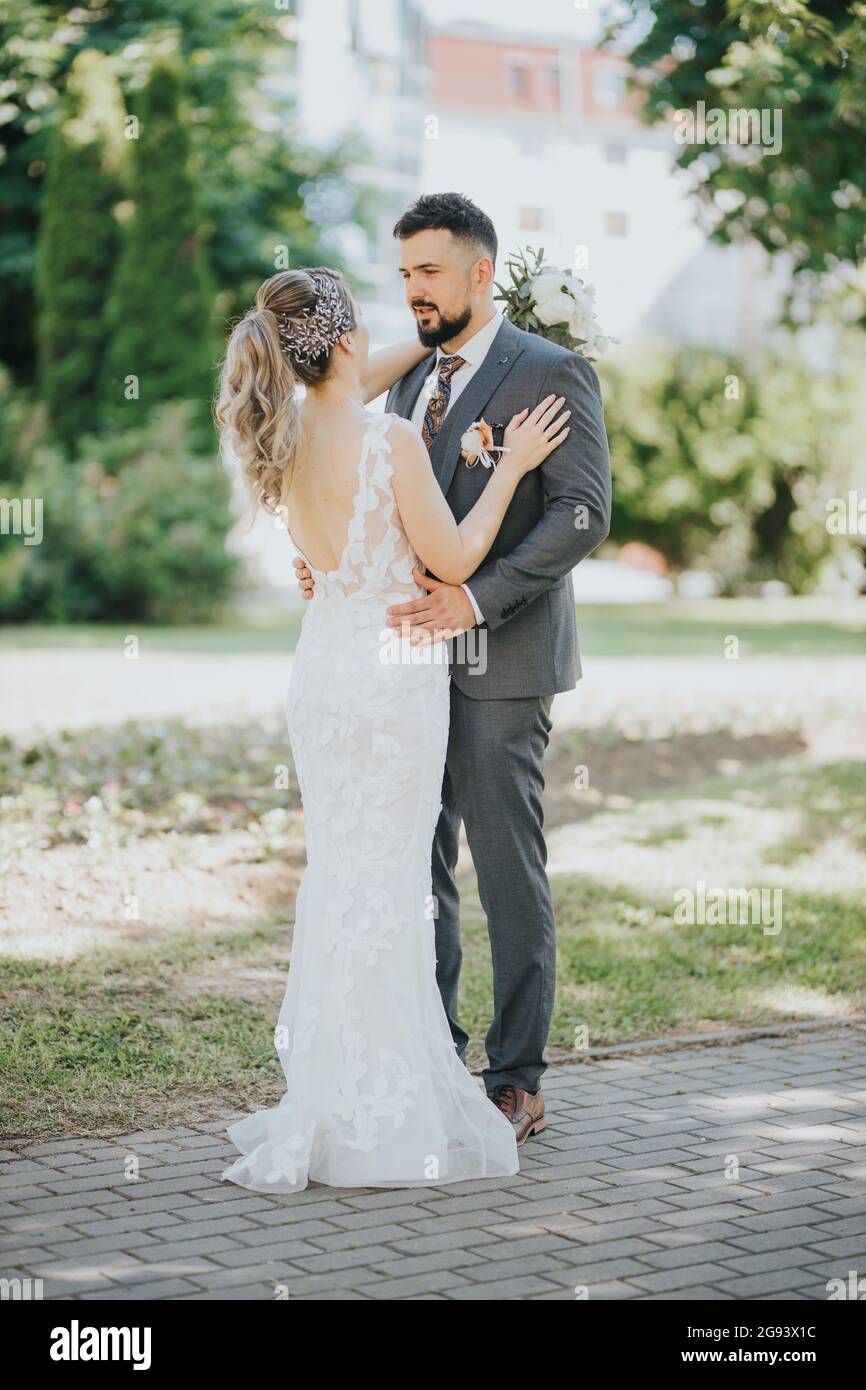 Beautiful hugging wedding couple is posing in the park Stock Photo - Alamy